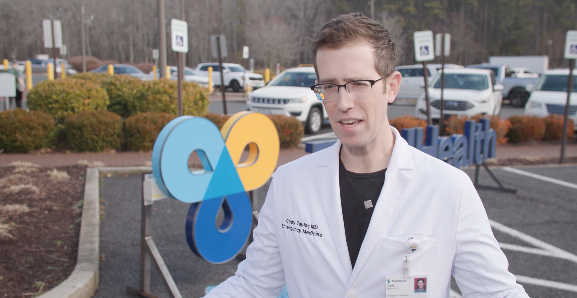 Dr. Cody Taylor speaks in front of a TidalHealth logo